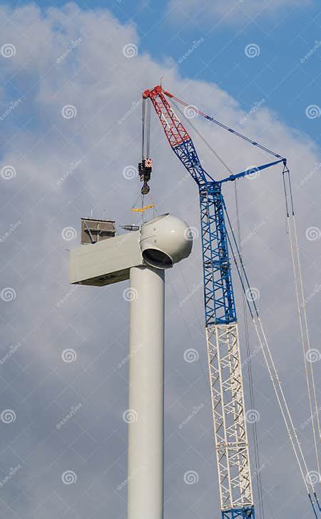 Crane Lifts The Nacelle Onto A Wind Turbine Tower During The