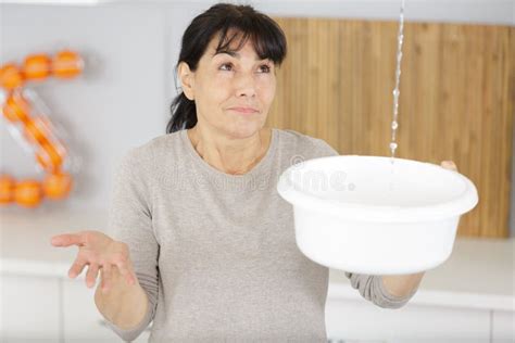 Donna Che Tiene Il Secchio Con Acqua Che Fuoriesce Immagine Stock