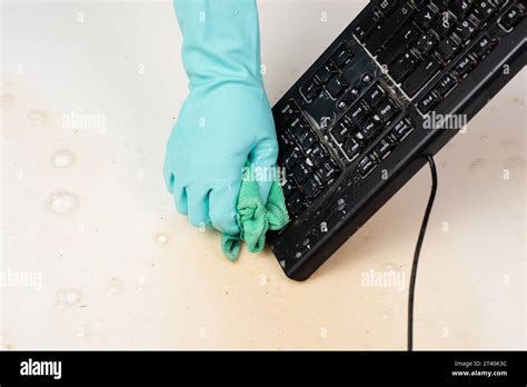 Cleaning Computer Keyboard In Office With Rubber Protective Glove
