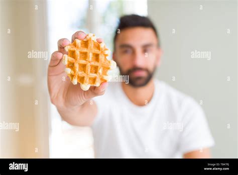 Handsome Hispanic Man Eating Sweet Belgian Waffle Pastry With A