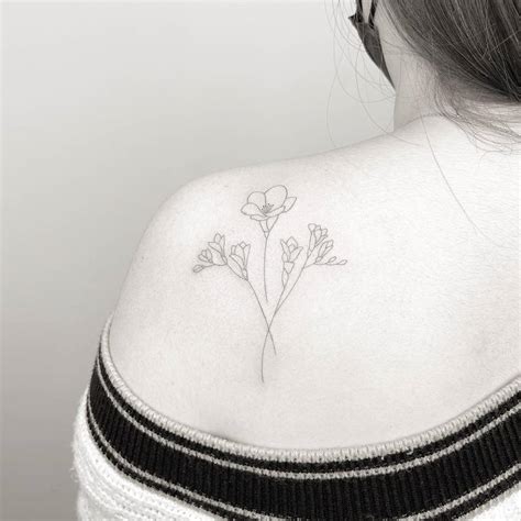 Fine Line Lily Flowers Tattooed On The Shoulder Blade