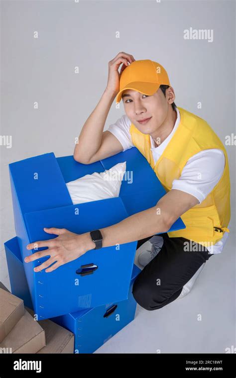 Millennials And Gen Z Korean Asian Young Man Organizing Moving Boxes