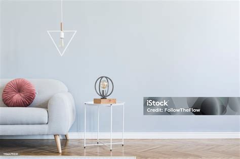 디자인 회색 소파 커피 테이블 램프 베개와 열린 공간의 미니멀하고 세련된 인테리어 회색 배경 벽 갈색 나무 마루 객실의 현대적인 개념입니다 템플릿 공간을 복사합니다 담