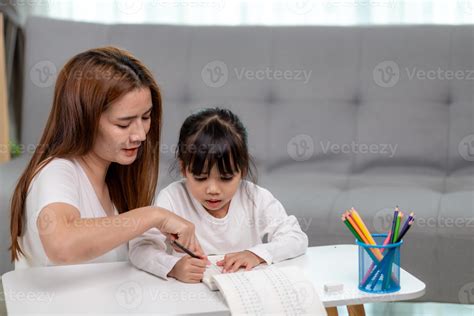 Belle Femme Asiatique Aidant Sa Fille à Faire Ses Devoirs à La Maison