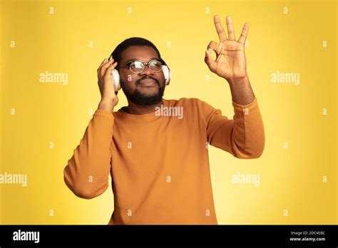 Enjoying Young African American Mans Portrait Isolated On Yellow