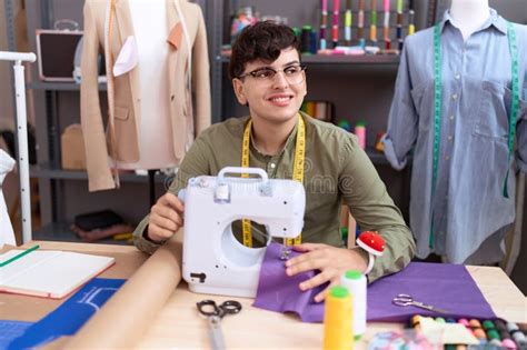 Non Binary Man Tailor Smiling Confident Using Sewing Machine At Atelier