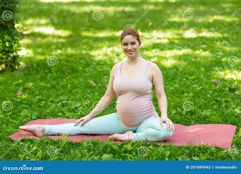 Pregnant Caucasian Woman Doing Yoga In The Park Lateral Tilt Stock