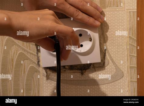 the hand includes a plug in an old broken socket in the hallway of the