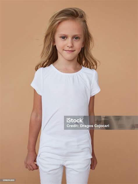 흰색 옷을 입고 물결 모양의 머리를 가진 예쁜 작은 소심한 소녀의 앞 초상화 수직 뷰입니다 8 9 살에 대한 스톡 사진 및 기타 이미지 Istock