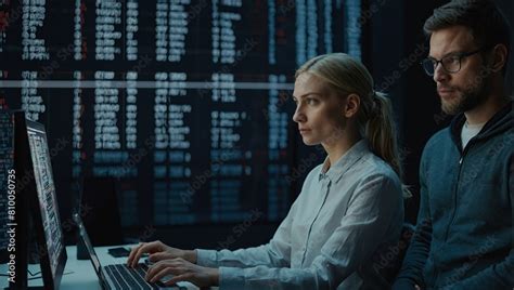 Two Diverse Developers Using Laptop Computer Discussing Lines Of Code