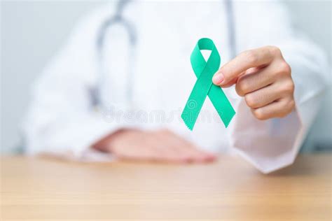 Doctor Holding Teal Ribbon For January Cervical Cancer Awareness Month