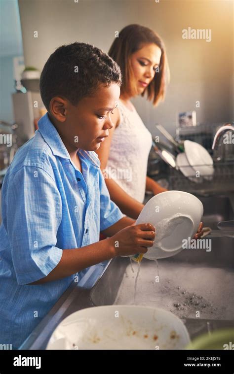 Hes Giving Mom A Helping Hand A Mother And Son Washing Dishes Together