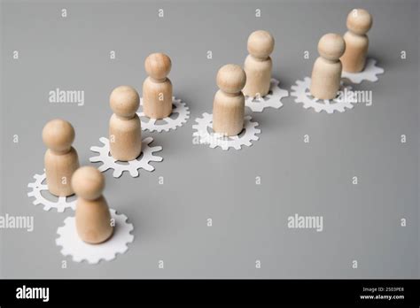 A Conceptual Image With Wooden Figures Standing On Interconnected Gears Teamwork Collaboration