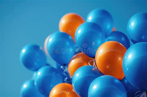 Bright Orange And Blue Balloons Floating In A Clear Blue Sky Cr Stock