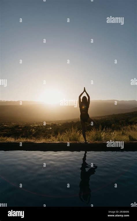 Woman Practicing Tree Pose At Poolside Stock Photo Alamy