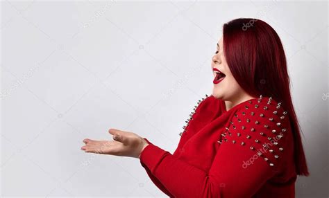 Modelo pelirroja gorda en blusa de púas rojas Actúa como si estuviera