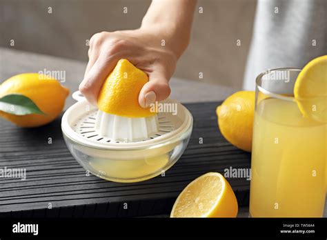 Woman squeezing lemon juice in kitchen Stock Photo - Alamy