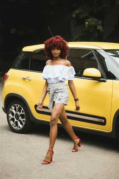 Woman Wearing White Off Shoulder Blouse Standing Next To Yellow Fiat