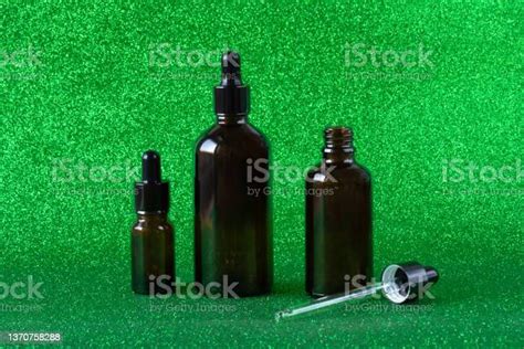 녹색 반짝이는 배경에 파이펫이 달린 유리 병 3개 화장품 병 모형 0명에 대한 스톡 사진 및 기타 이미지 0명 건강관리와 의술 녹색 Istock