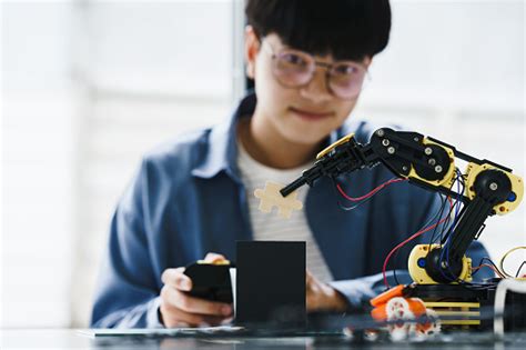 아시아 십대 학생들은 집에서 로봇 팔과 로봇 자동차 숙제 프로젝트를 하거나 놀고 회로를 조립하고 코딩합니다 로봇 공학 프로그래밍