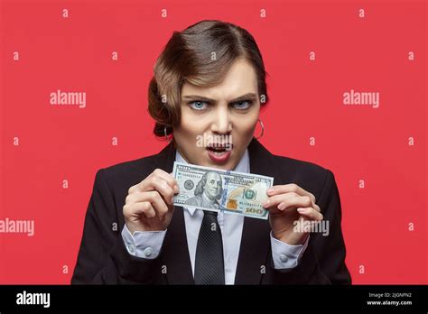 Attractive Girl In Retro Style Holds A 100 Dollar Bill In Front Of Her