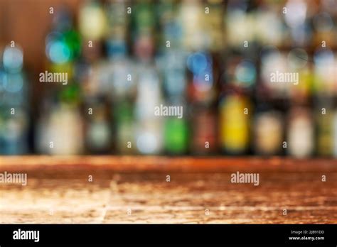 Empty Wooden Bar Counter With Defocused Background And Bottles Of