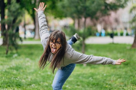 쾌활한 여자는 재미있는 얼굴을 만들고 혀를 내밀고 야외에서 즐거운 시간을 보낸다 개성 개념에 대한 스톡 사진 및 기타 이미지 개성 개념 계절 공원 Istock