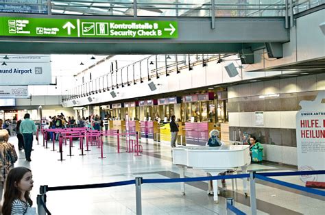 도르트문트 공항 독일의 다채로운 출발 터미널에서 체크인 기다리는 승객 출발 디스플레이에 출발 게이트 보안 체크 배너 간판에 대한