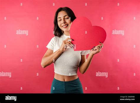 Brunette Woman Wearing White Ribbed Crop Isolated Over Red Background