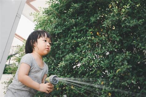 Premium Photo Cute Girl Watering Plant Outdoors