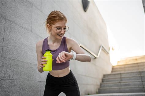 Smiling Young Beautiful Redhead Woman Checking Her Physical Activity On