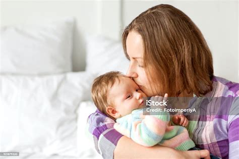 하얀 침대에 그녀의 아기와 엄마 신생아는 카메라 보고입니다 행복 한 어머니 개념 2명에 대한 스톡 사진 및 기타 이미지 2명