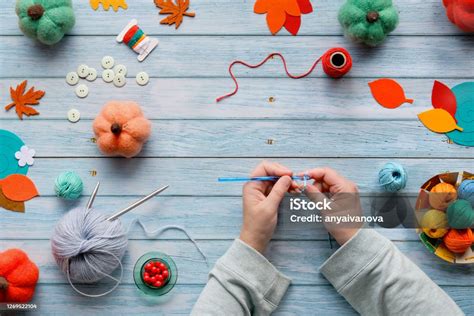 왼손잡이 니트 크로 셰 뜨개질 왼손잡이 여성 원사 공 양모 번들 장식 가을 펠트 호박과 단풍의 손으로 나무 테이블의 상단 보기 퇴색 된 나무에 계절 플랫 누워 10월에 대한