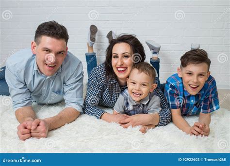 Happy Family Mother Father And Two Sons Having Fun Lying On The Floor Stock Photo Image Of