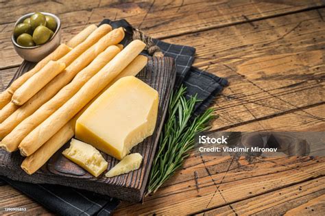 전통적인 이탈리아 전채 그리시니 빵은 올리브와 파르 메산 치즈가있는 나무 보드에 붙어 있습니다 나무 베이크그라운드 상단 보기