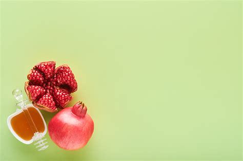 로쉬 하샤나 익은 석류 사과 꿀과 해바라기 녹색 배경에 노란 꽃 상징을 가진 작곡 유태인 Rosh Hashanah 휴일 속성 복사 공간이 있는 위쪽 보기입니다 0명에 대한