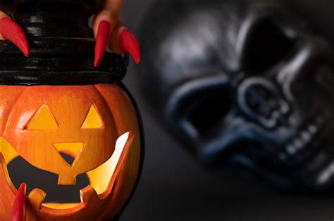 할로윈 배경 어두운 배경에 빛나는 호박과 검은 두개골 긴 빨간 발톱을 가진 인간의 손가락 10월에 대한 스톡 사진 및 기타