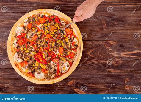 Man Cut The Pizza With A Pizza Cutter Top View And Copy Space