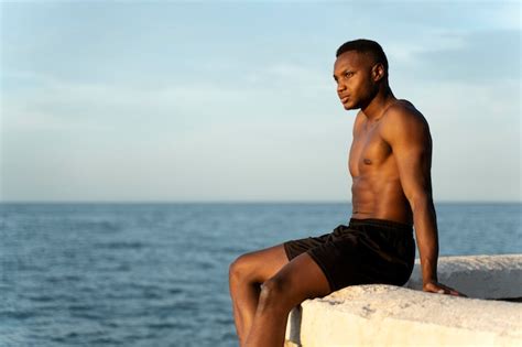 Hombre Con El Torso Desnudo Parado En La Playa Y Mirando Hacia Otro