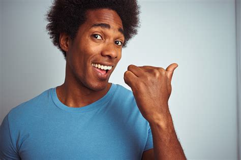 아프리카계 미국인 남자 와 아프리카 계 미국인 남자 와 Afro 머리 입고 푸른 티셔츠 위에 서 서 고립 된 흰색 배경 가리키는