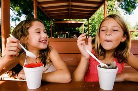 Two Girls Eating Shaved Ice Superstock