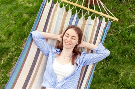 Cheerful Girl Lies On Comfortable Hammock In Garden In Summer And