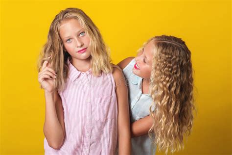 Funny Girls Twins Have Fun Together On Yellow Background Stock Image