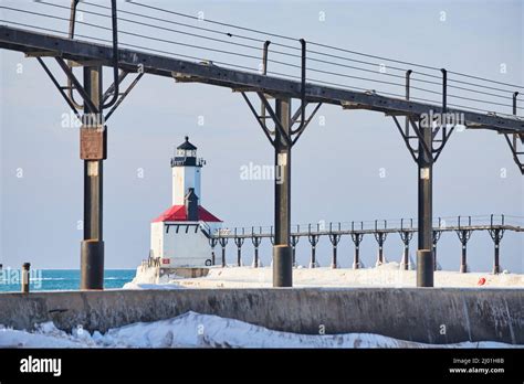 Winter View Of Red And White Lighthouse Through Walkway Railing Stock