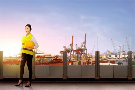 사무실 테라스에 서 있는 단단한 모자를 들고 안전 조끼를 가진 예쁜 아시아 여자 노동자 경관에 대한 스톡 사진 및 기타 이미지 경관 고용과 노동 노랑 Istock