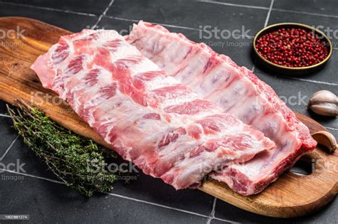 신선한 돼지 고기 갈비 백리향과 향신료가 들어간 나무 판에 생 예비 허리 갈비 검은 배경입니다 상위 뷰 0명에 대한 스톡 사진