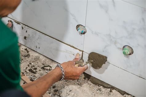 Premium Photo Male Tiler Using Trowel Laying Marble Tile With Cement