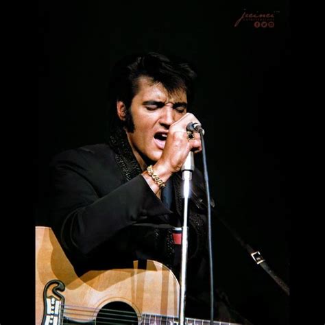 Elvis Presley Singing Into A Microphone While Holding An Acoustic