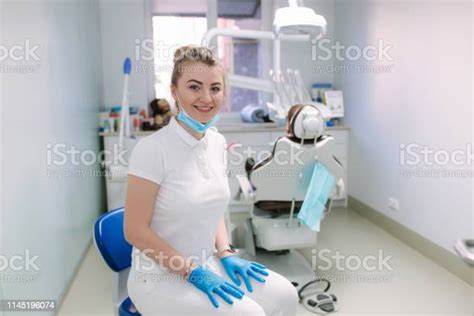 진료소에 있는 젊은 치과 의사는 장비와 미소 앞에 서 있으십시오 Radiographer에 대한 스톡 사진 및 기타 이미지