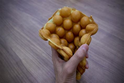 Premium Photo High Angle View Of Person Holding Bubble Waffle Bread